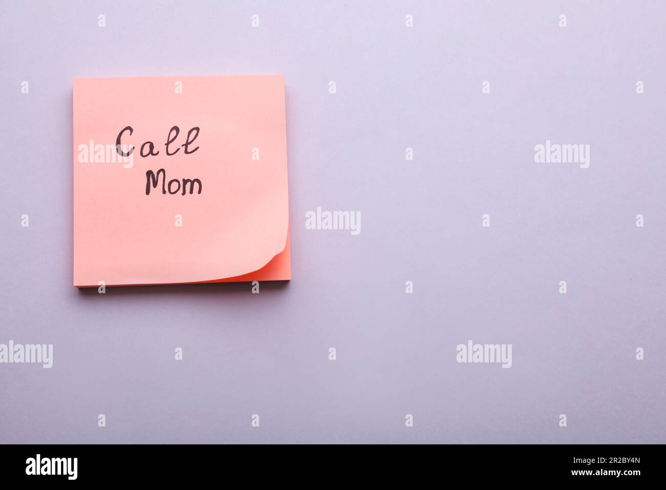 Paper note with phrase Call mom on light grey background, top view ...