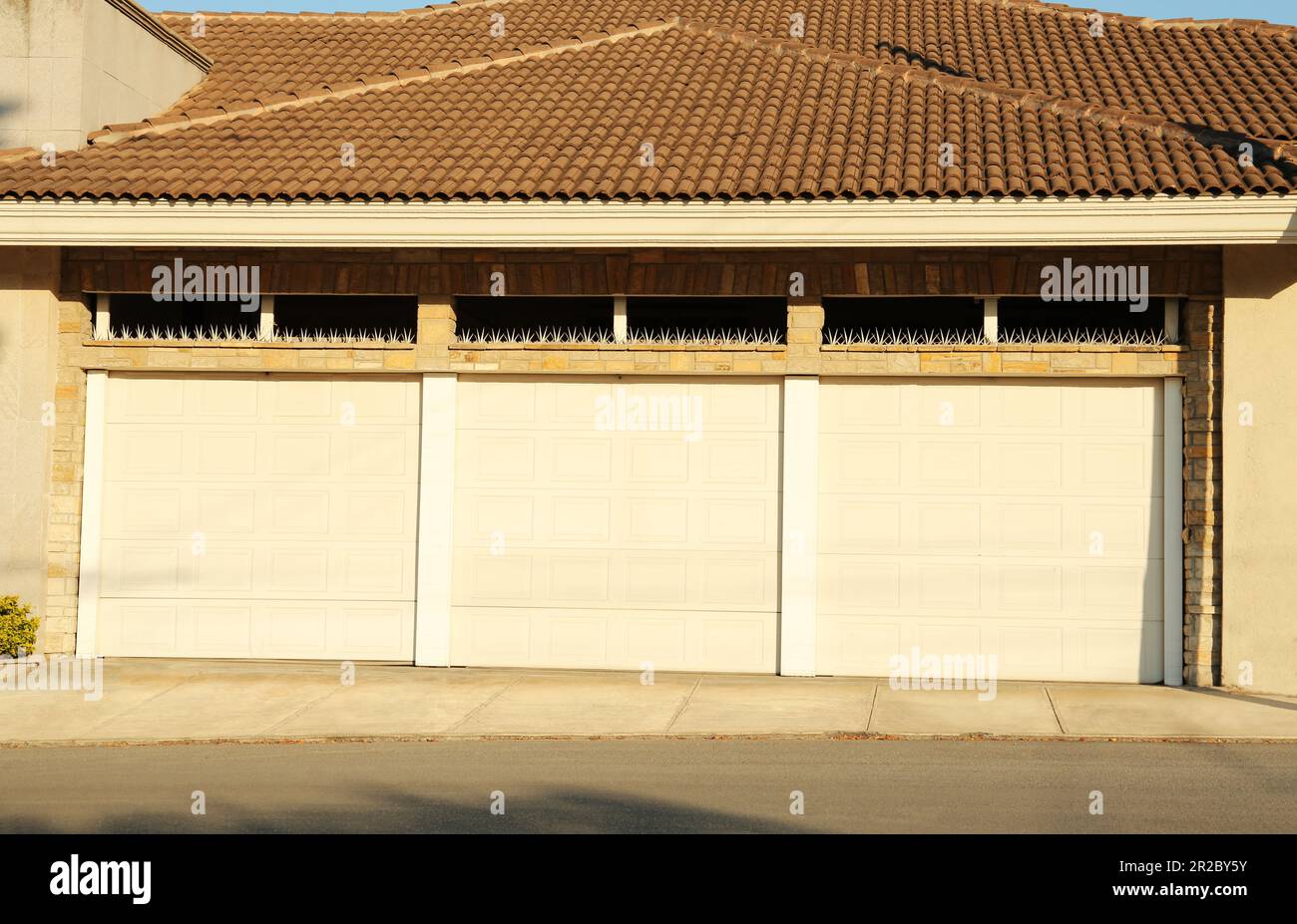 Garage building with closed white sectional gates Stock Photo - Alamy