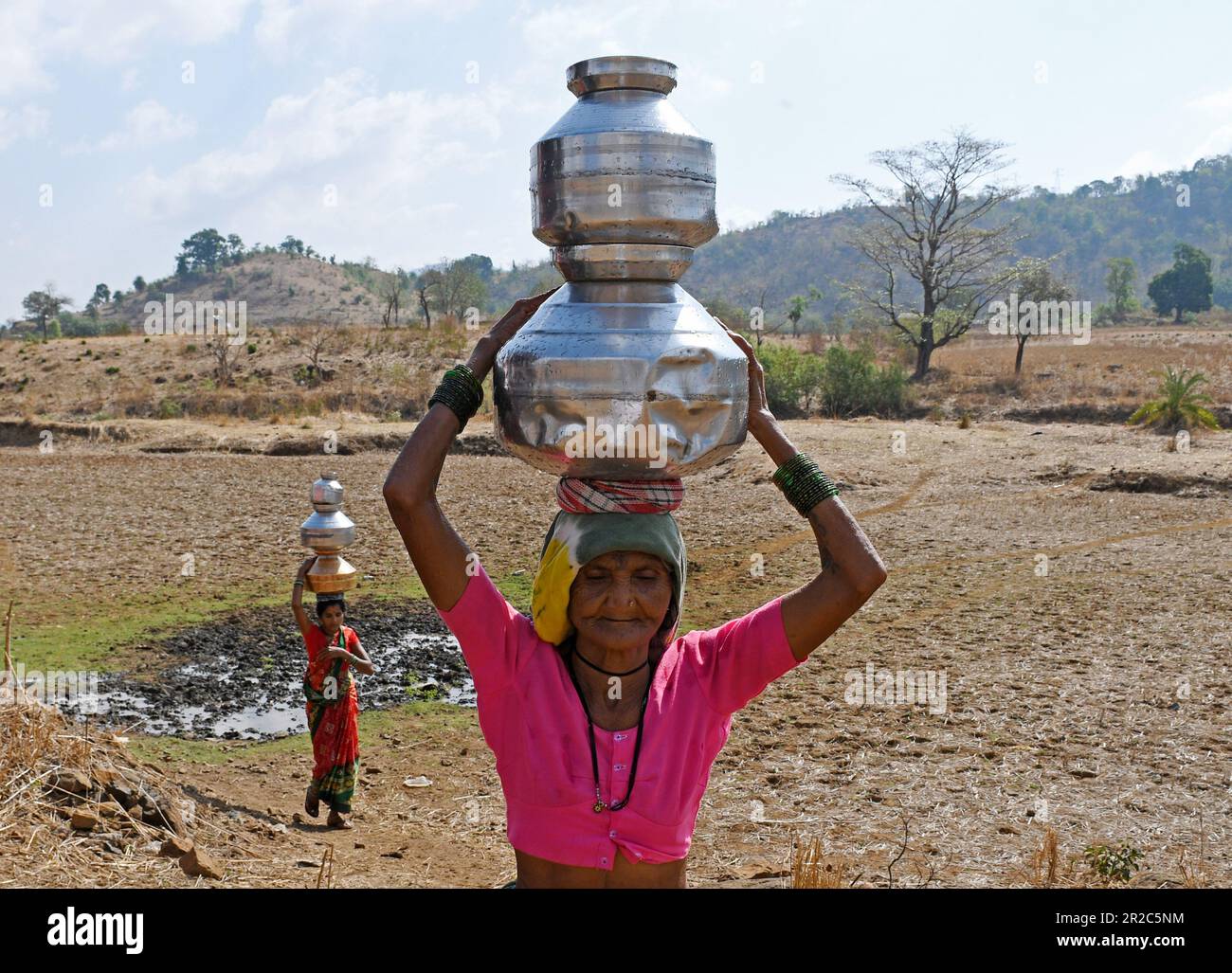 Mumbai, India. 16th May, 2023. Women balance pots of water on their ...