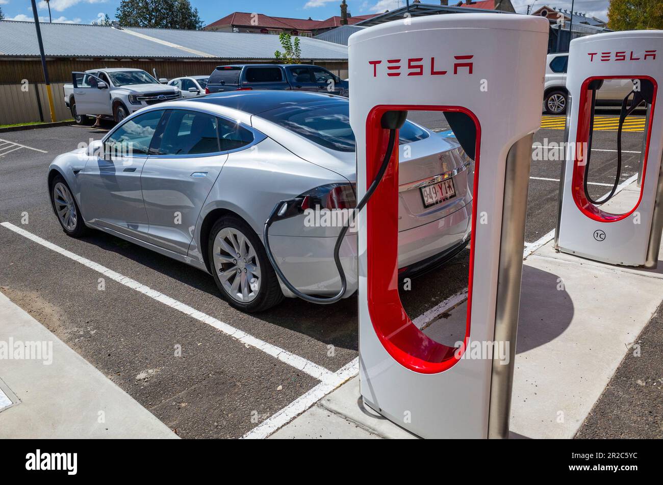 Silver Tesla 3 charging at electric vehicle charging station in ...