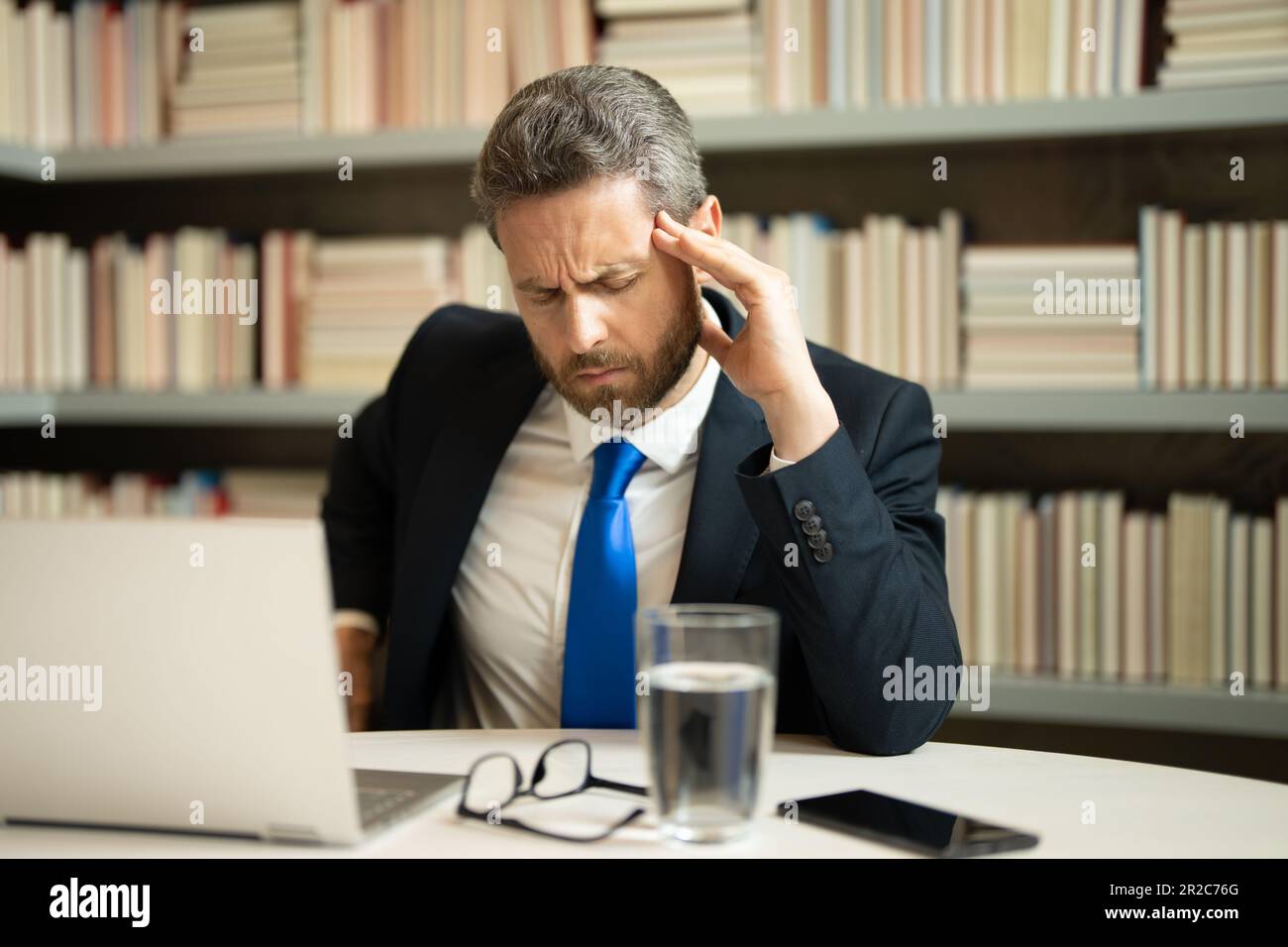 Headache and eye strain on laptop. Business man with stress and fatigue eyestrain. Businessman ...