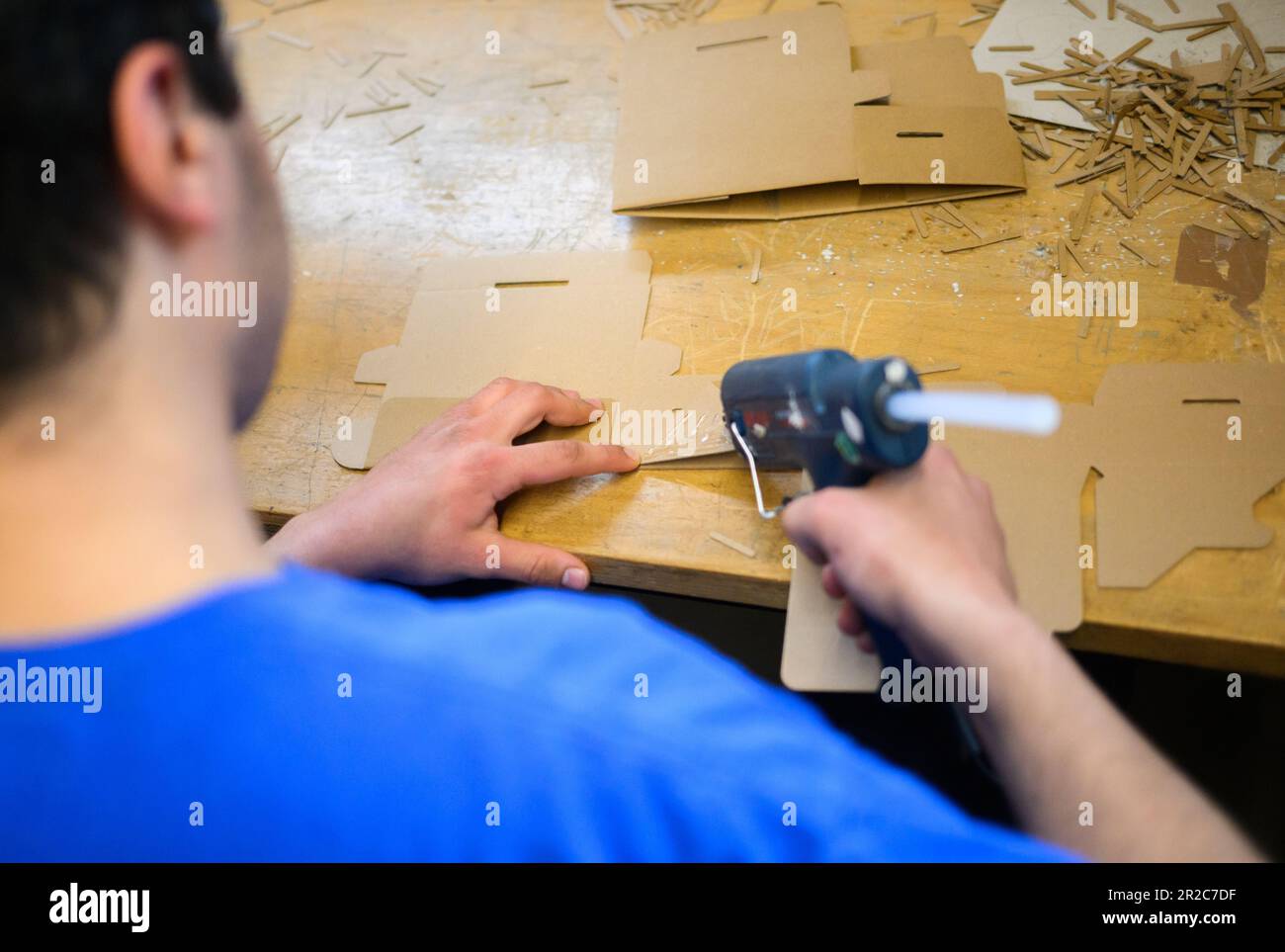 Hameln, Germany. 11th May, 2023. A young inmate glues cardboard boxes ...