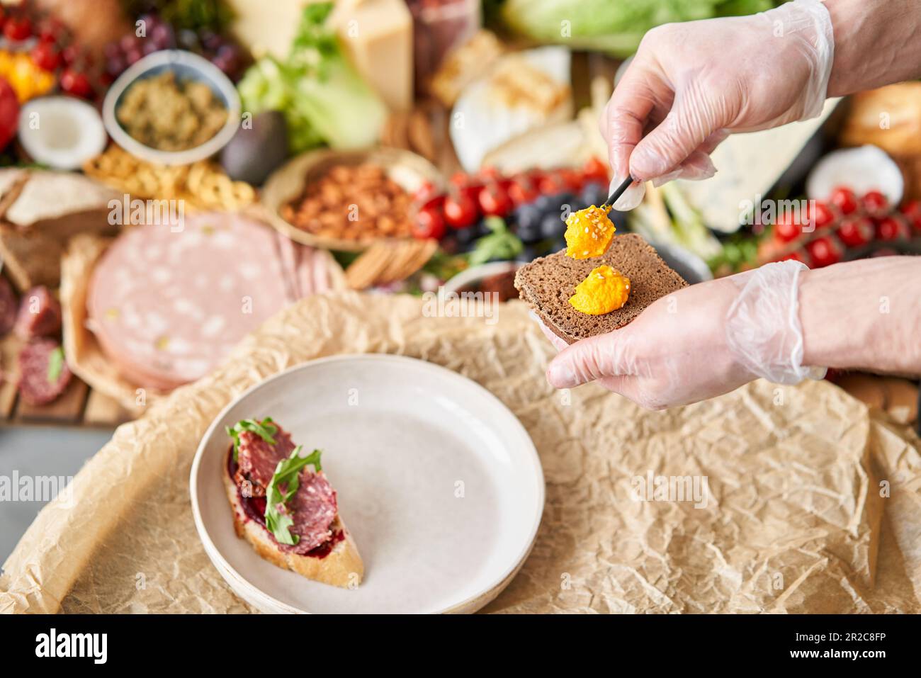 The waiter makes bruschetta or tapas. Table full of mediterranean ...