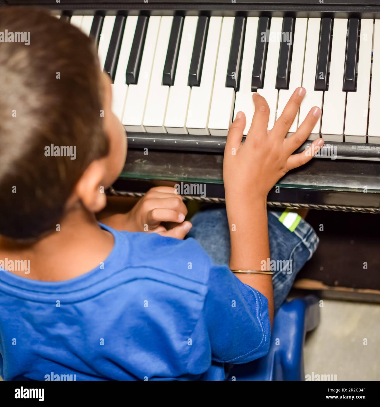 Asian boy playing the synthesizer or piano. Cute little kid learning ...