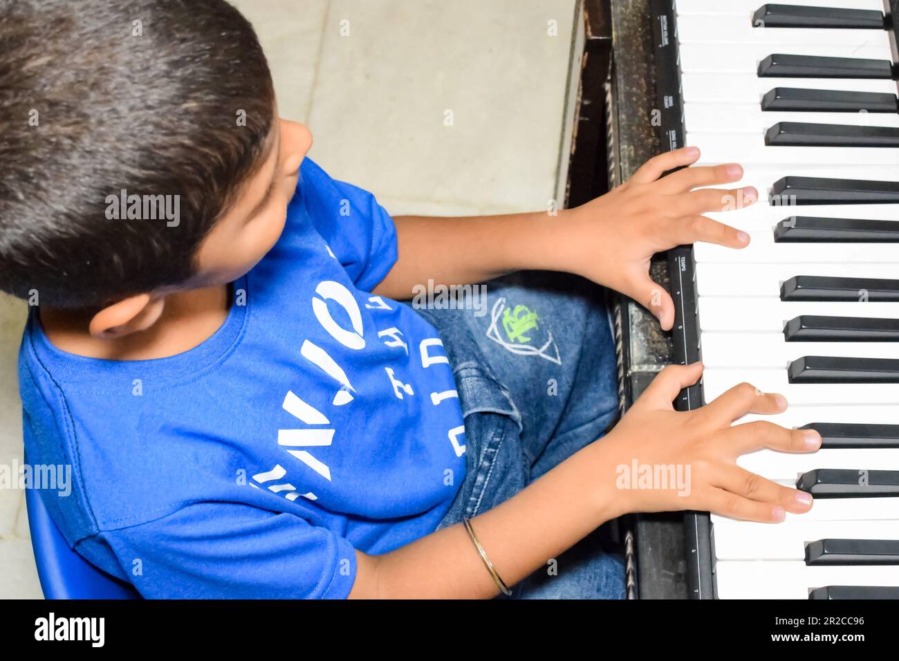 Asian boy playing the synthesizer or piano. Cute little kid learning ...