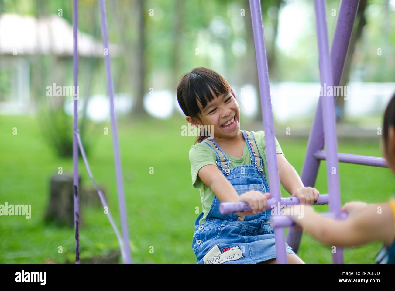 Two cute little sisters having fun playing in the playground during ...