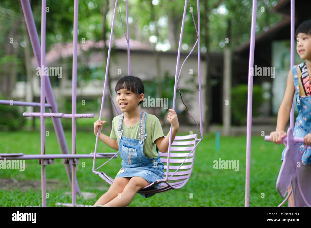 Two cute little sisters having fun playing in the playground during ...