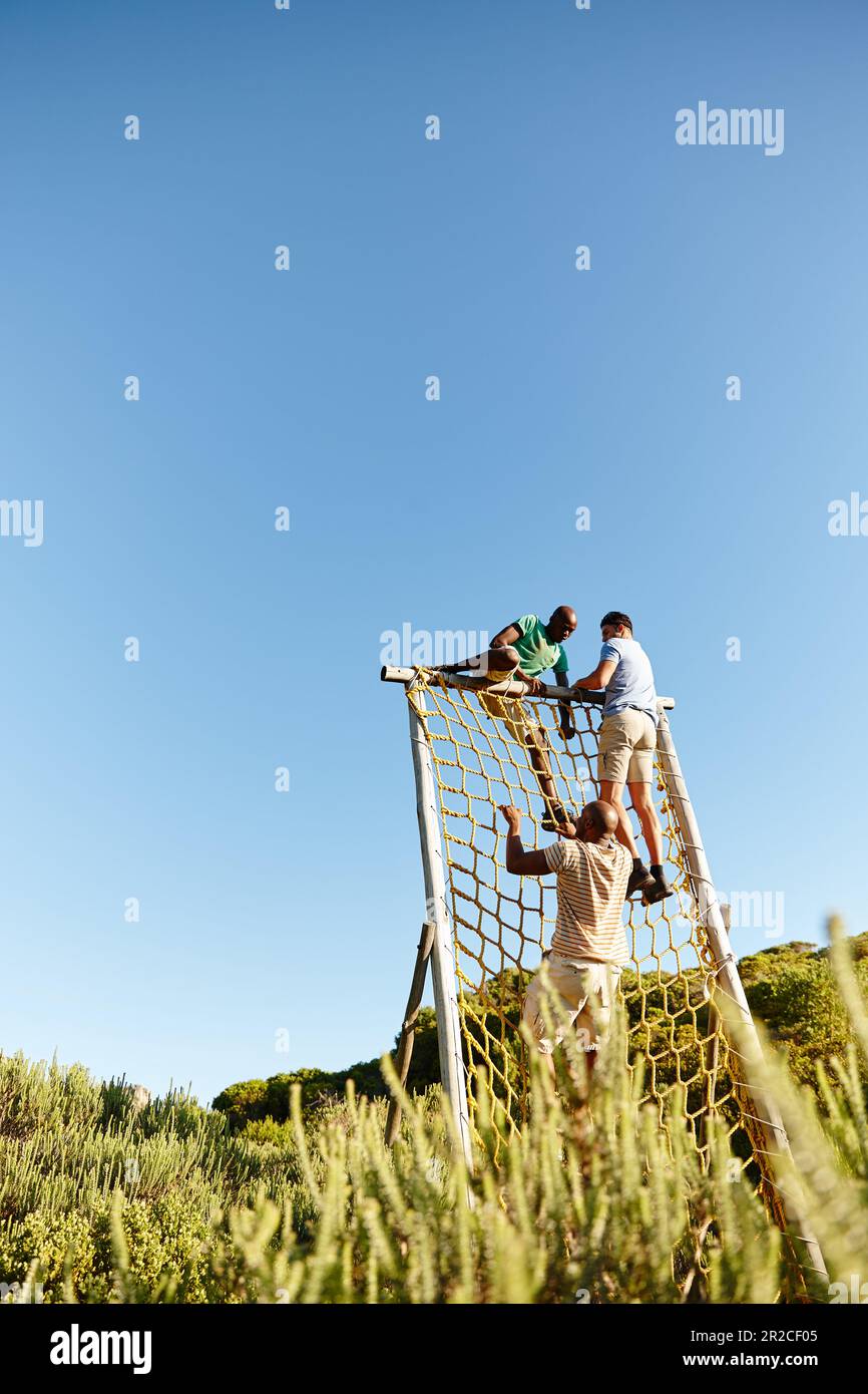 No obstacle too big...a group of men going through an obstacle course ...