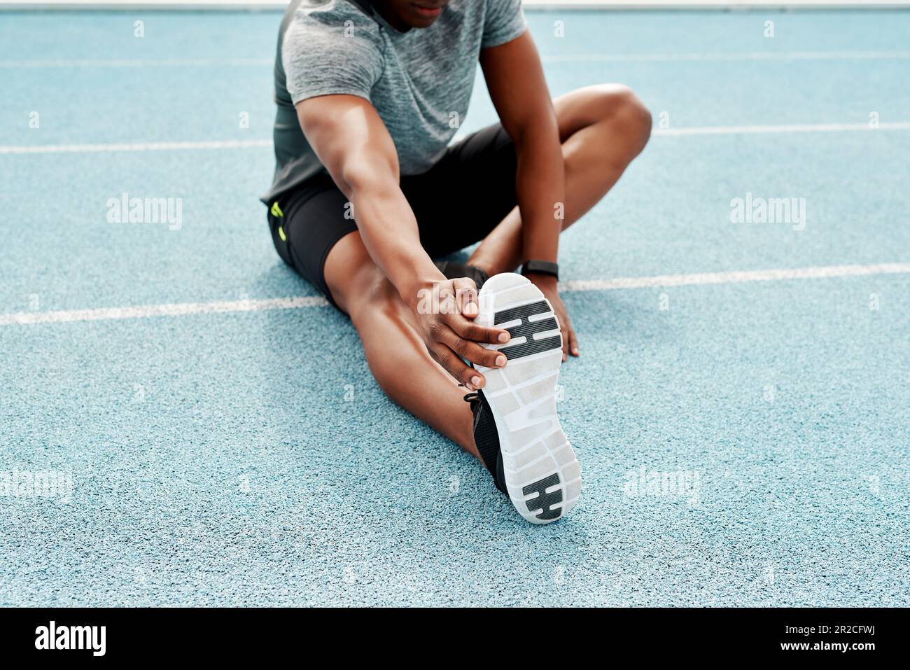 Athlete, sitting and track for stretching legs to start training ...