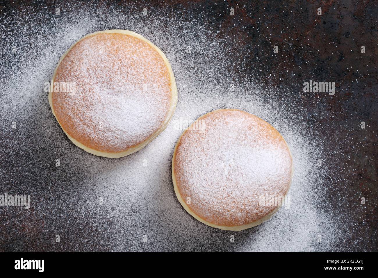 Doughnuts dusted with icing sugar on grunge metal background, top view ...