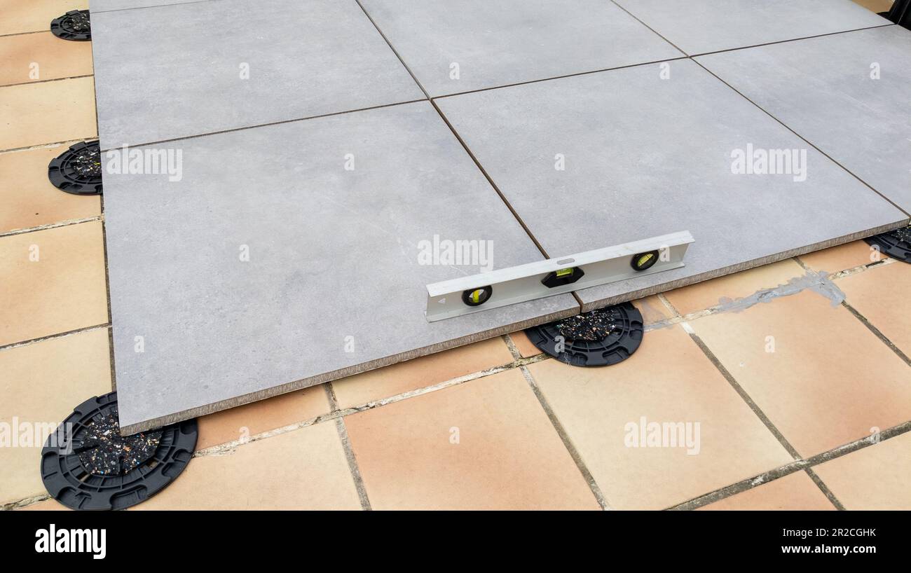 Exterior pavement tiles installation on the house terrace with bubble ...