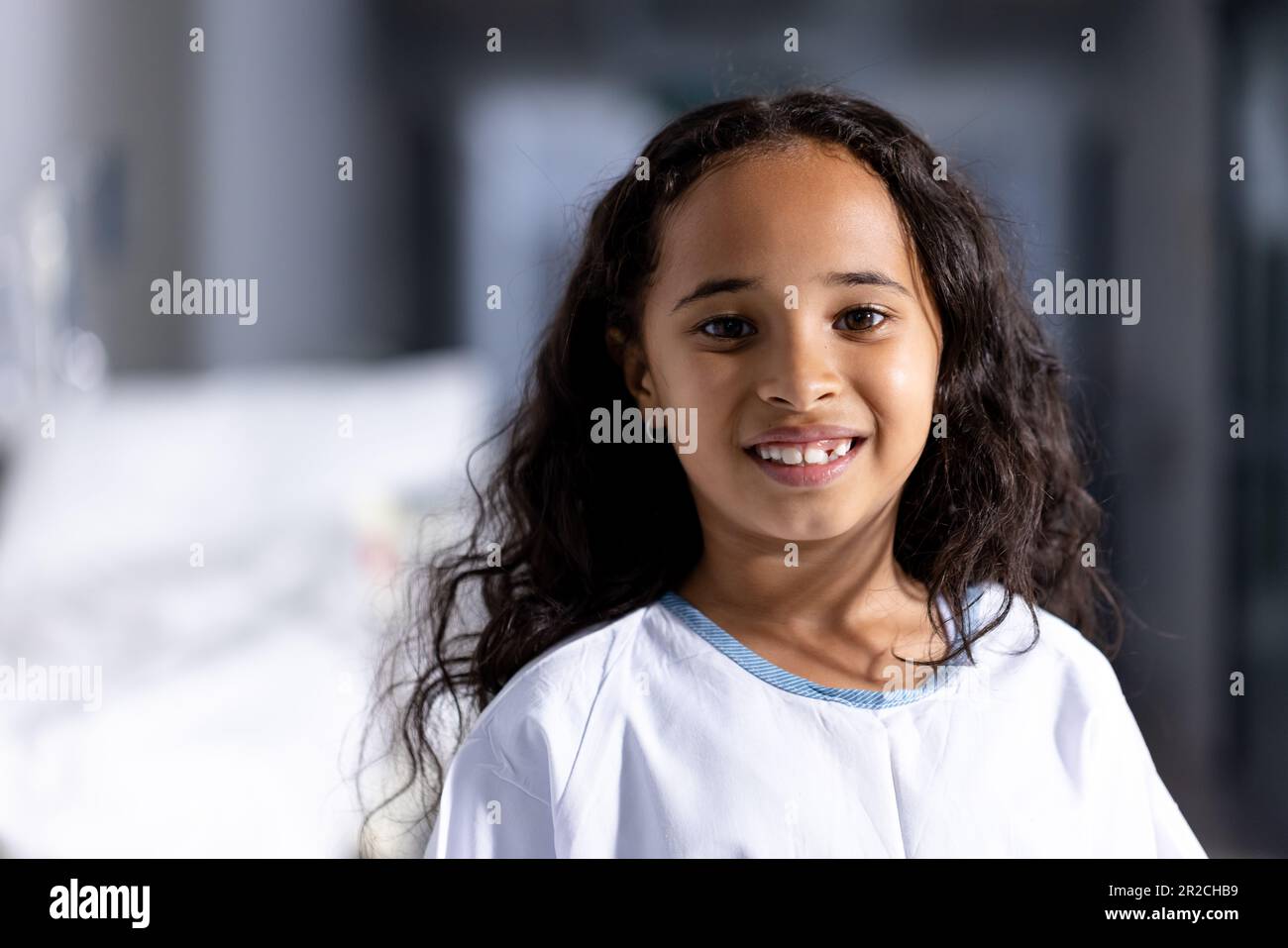 Portrait of happy biracial girl patient with long hair smiling in ...