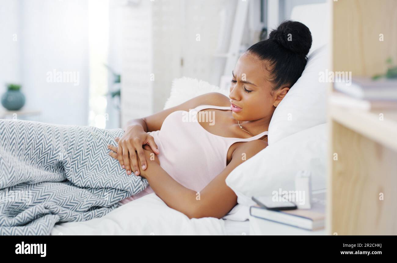 Woman in bed, stomach pain and period cramps with endometriosis, health ...