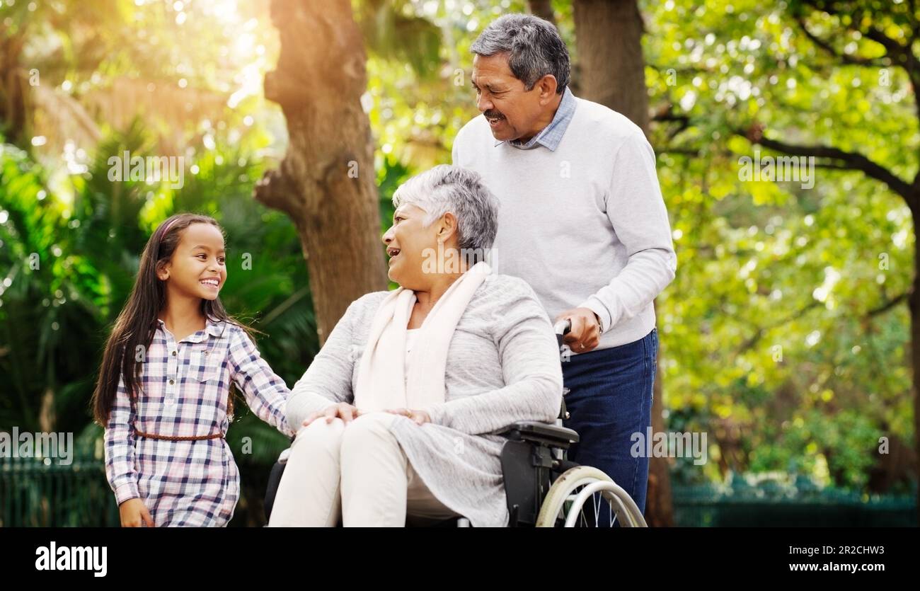 Grandparents, park and a senior woman in a wheelchair together with her ...