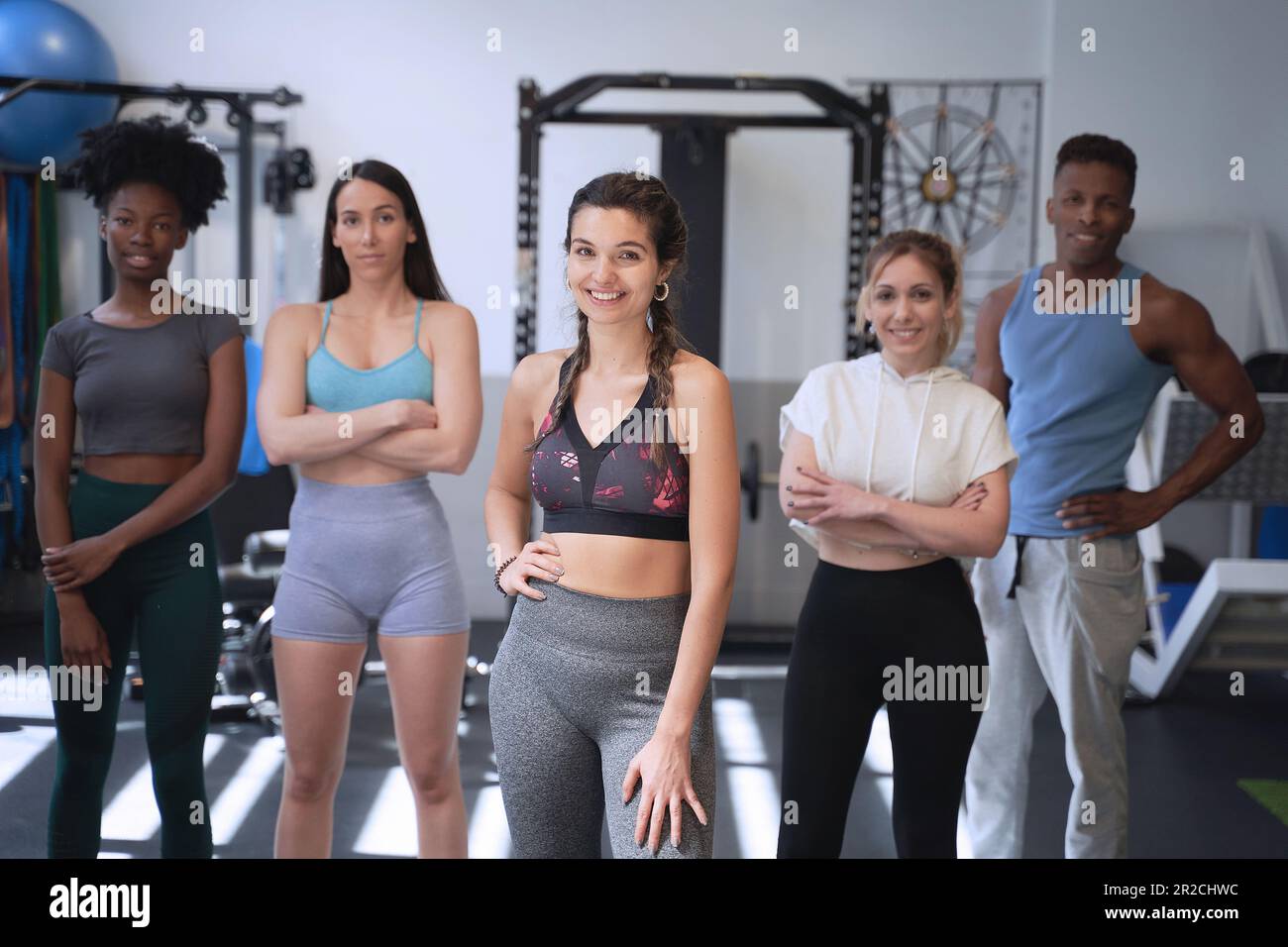 Female fitness trainer standing in front of group in the gym. Sport ...