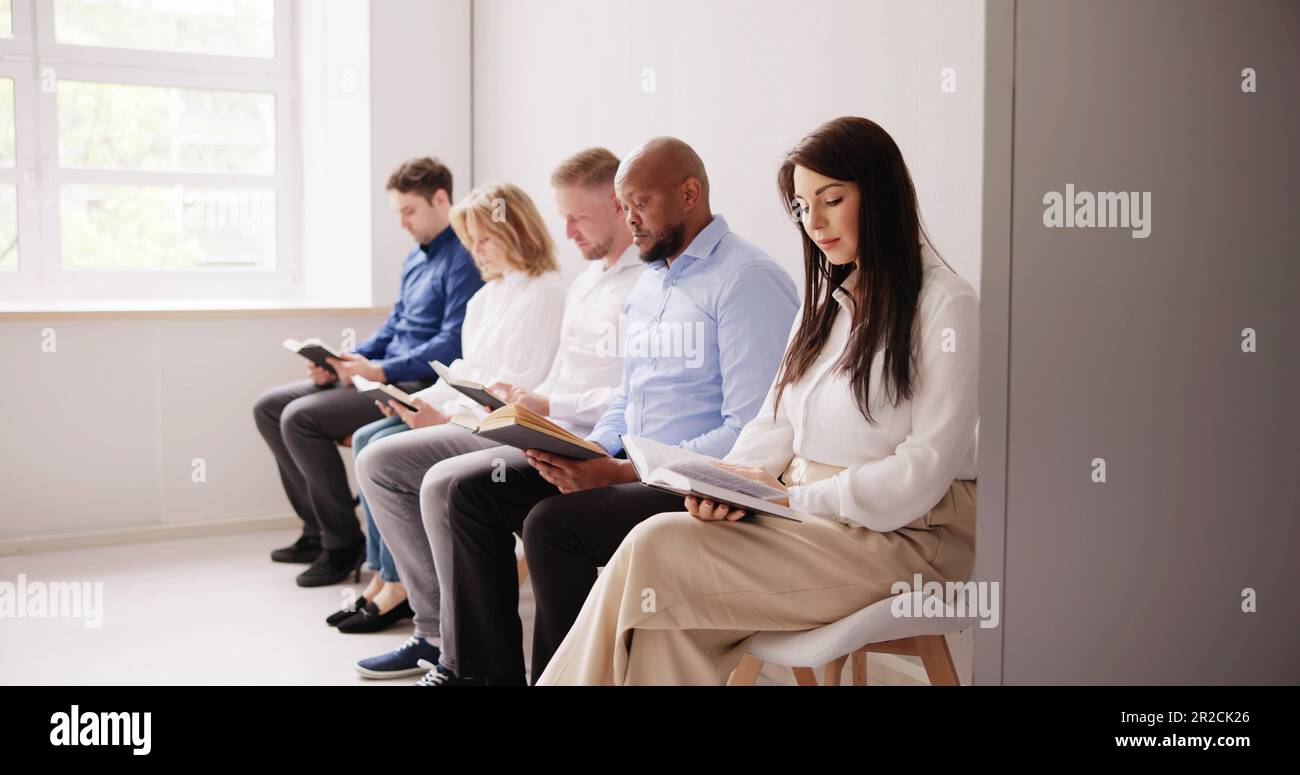 People Sitting In A Row Reading Bible Stock Photo - Alamy