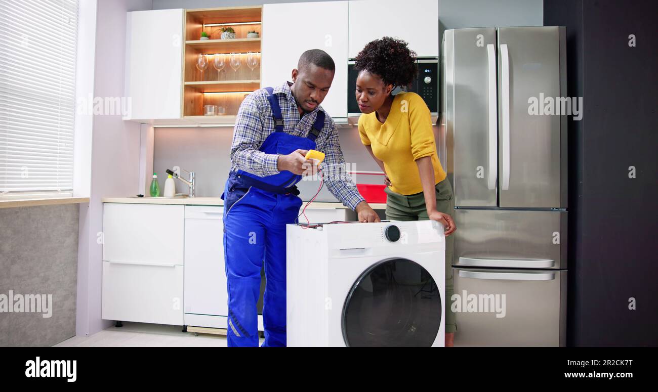 Young African American Technician Repairing Washing Machine In Kitchen ...