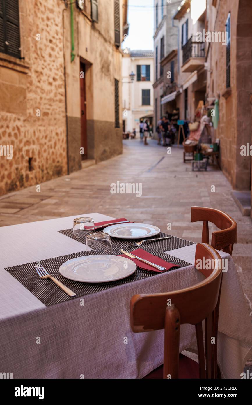 Set table of restaurant on the street in Alcudia, Mallorca. Traditional ...