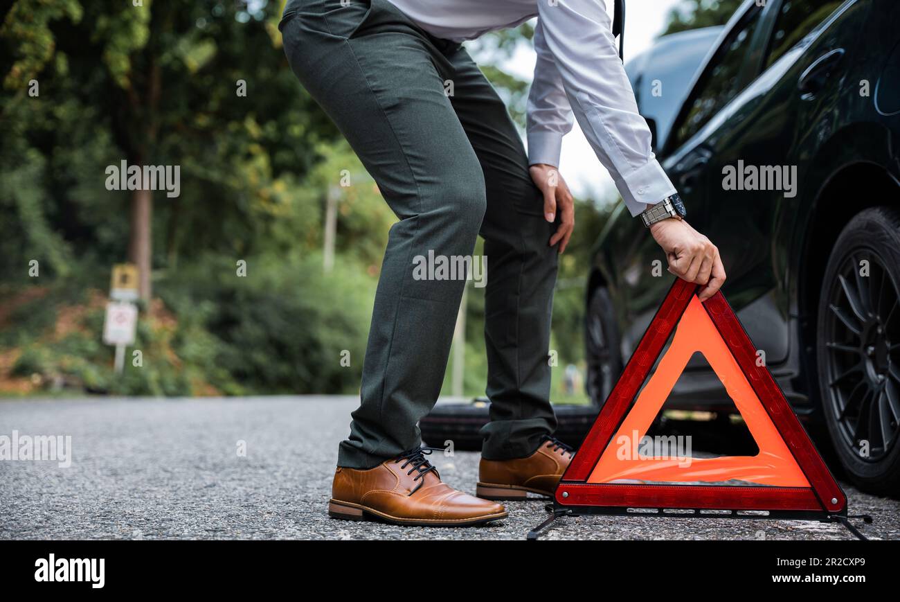 Man take down red warning triangle Stock Photo - Alamy