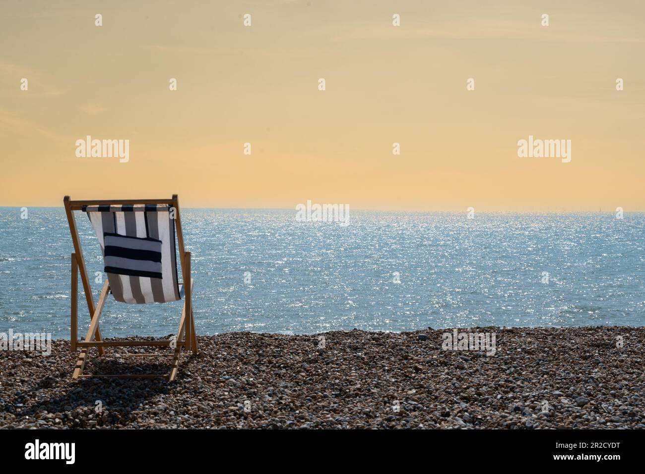 Deck Chair on pebble beach Stock Photo - Alamy