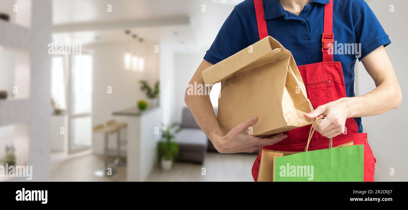 box with fast food being carried by delivery man in uniform for one of ...