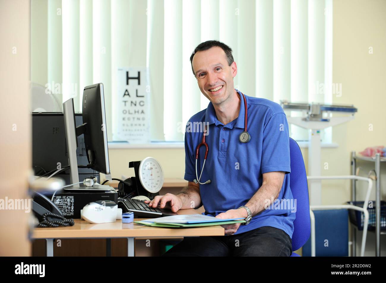 A NHS GP Doctor pictured in his general surgery. North Devon England UK ...