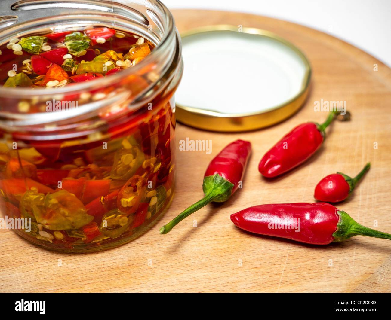 glass with red hot peppers chopped preserved in oil and red peppers on ...