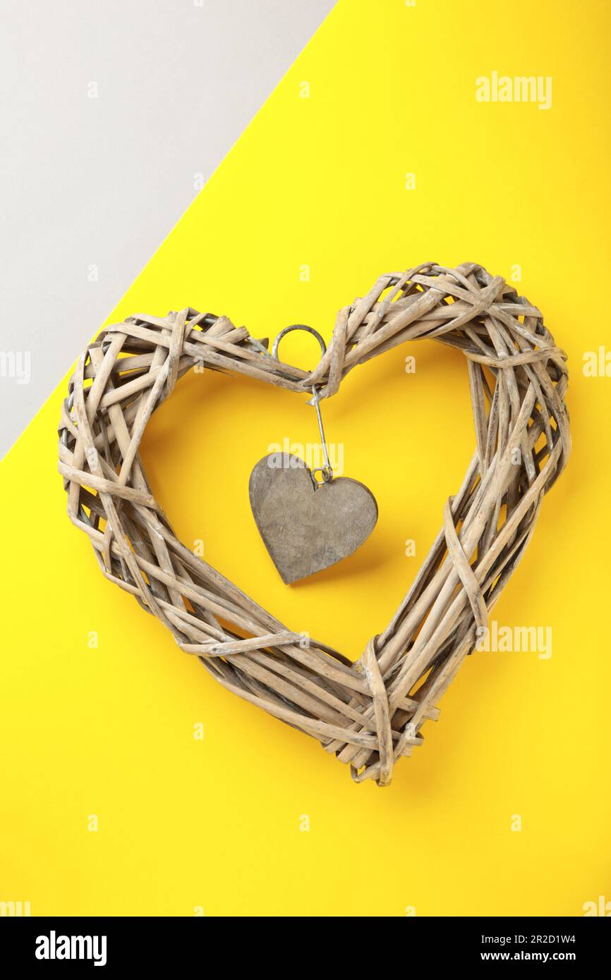 Weaved wooden heart on yellow and grey background. Colour trend 2021 ...