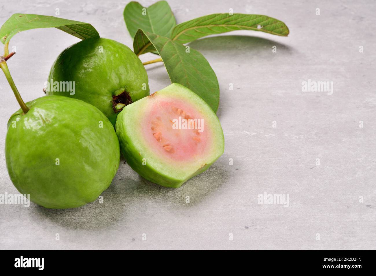 Pink guava fruits isolated on concrete background.Guava fruit with leaf ...