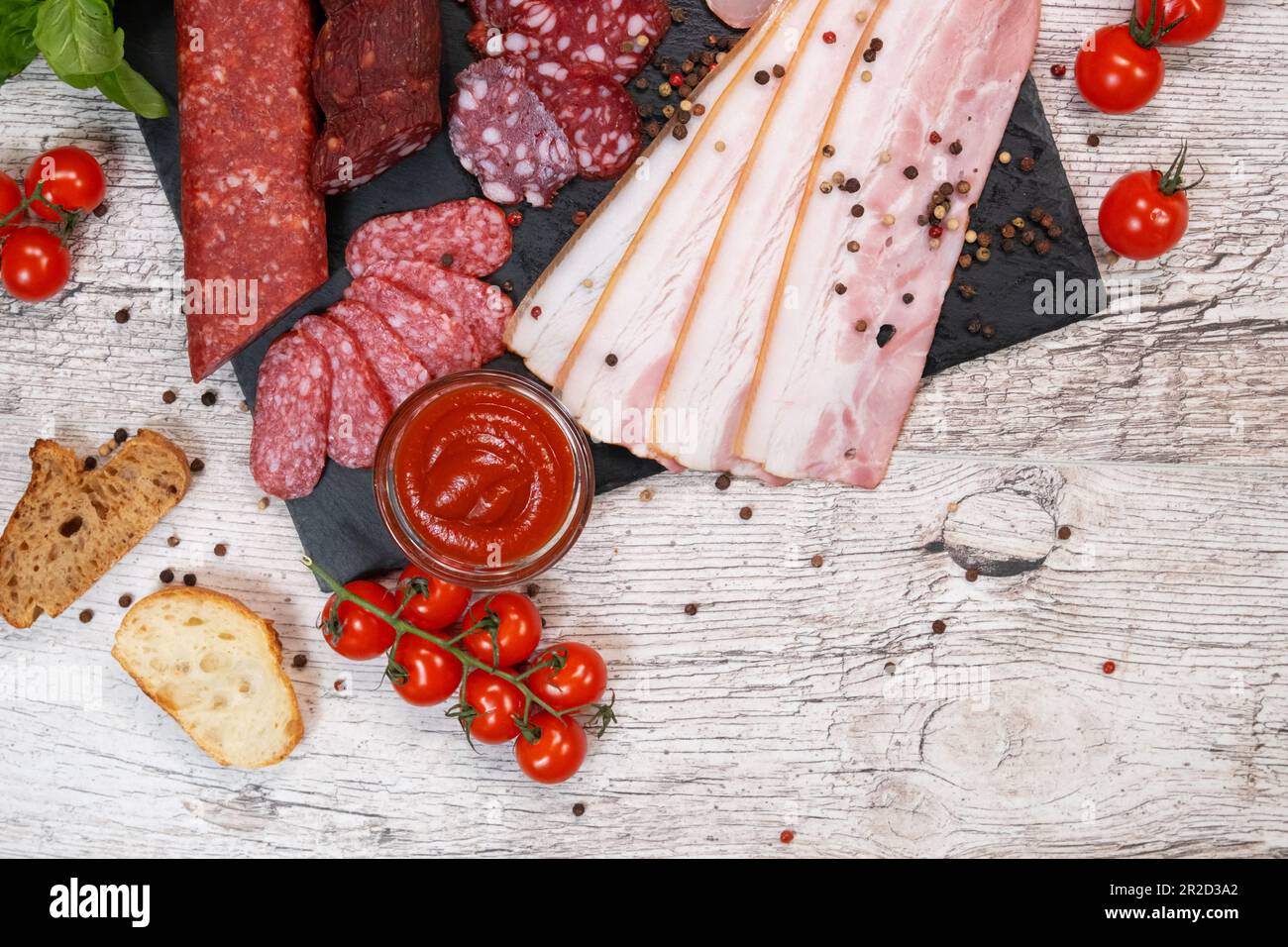 Antipasti different types of sausages and lard on a graphite board .Top ...