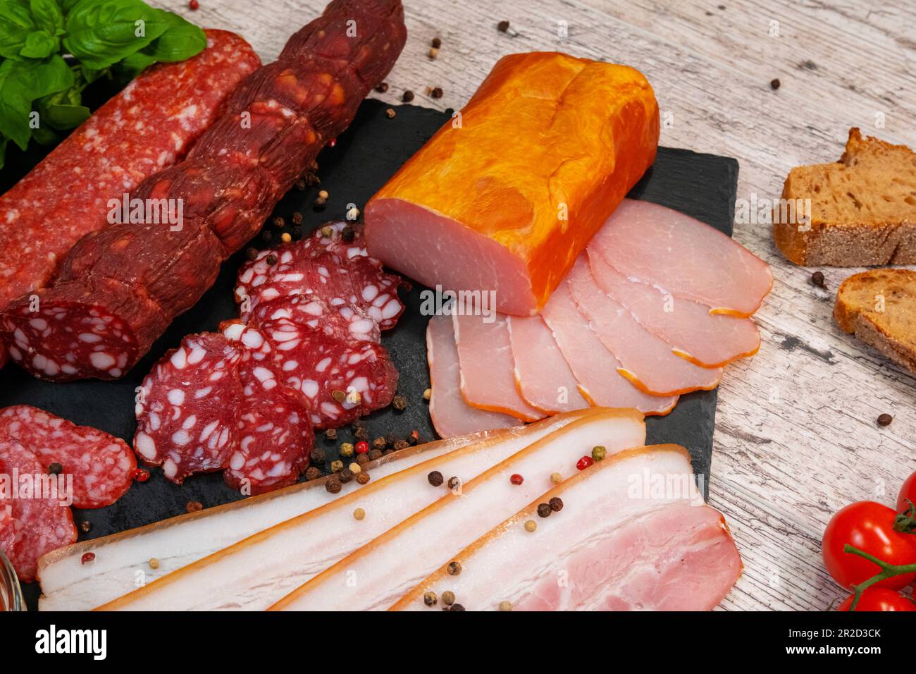 Antipasti different types of sausages and lard on a graphite board .Top ...