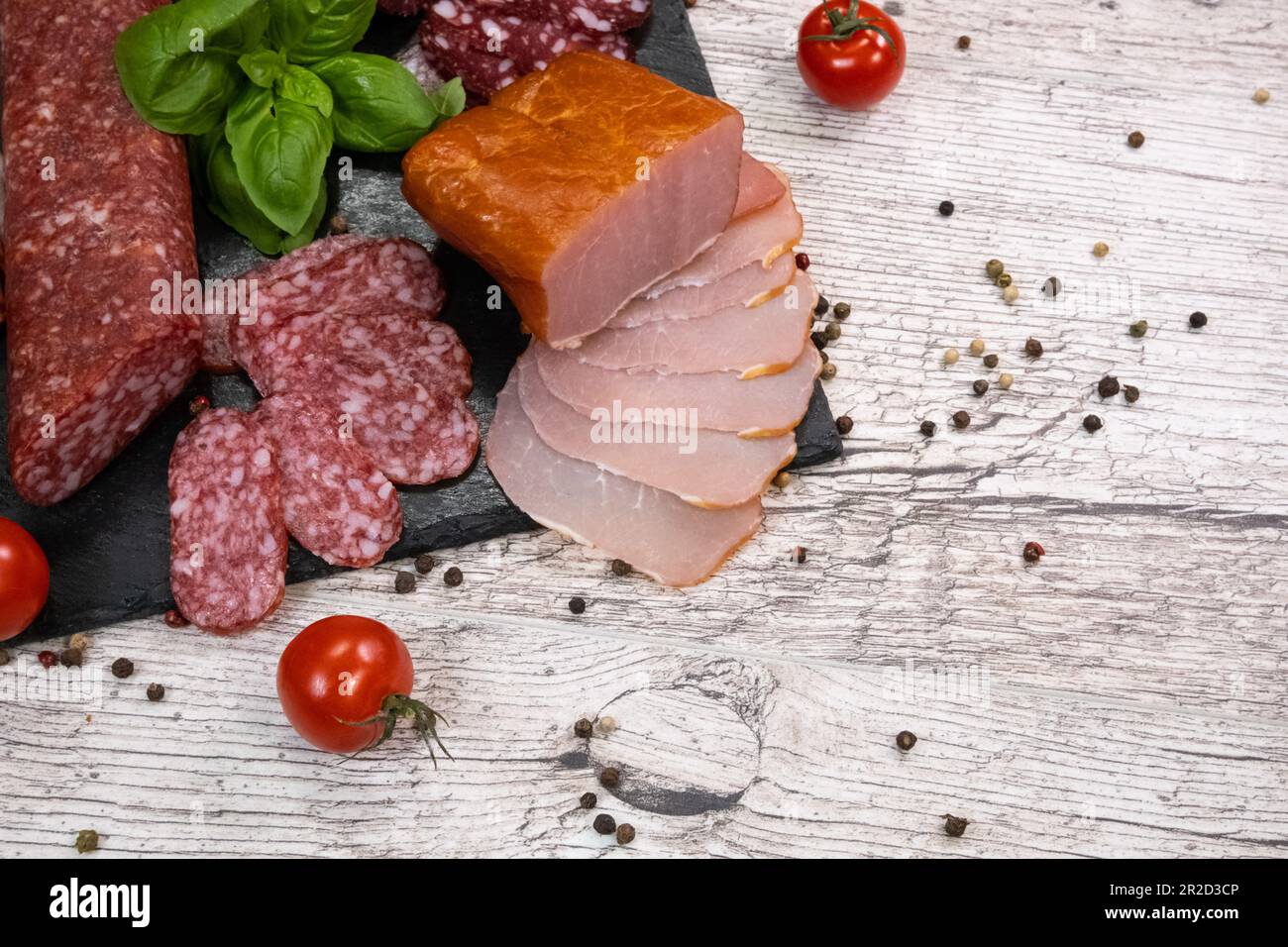 Antipasti different types of sausages and lard on a graphite board .Top ...