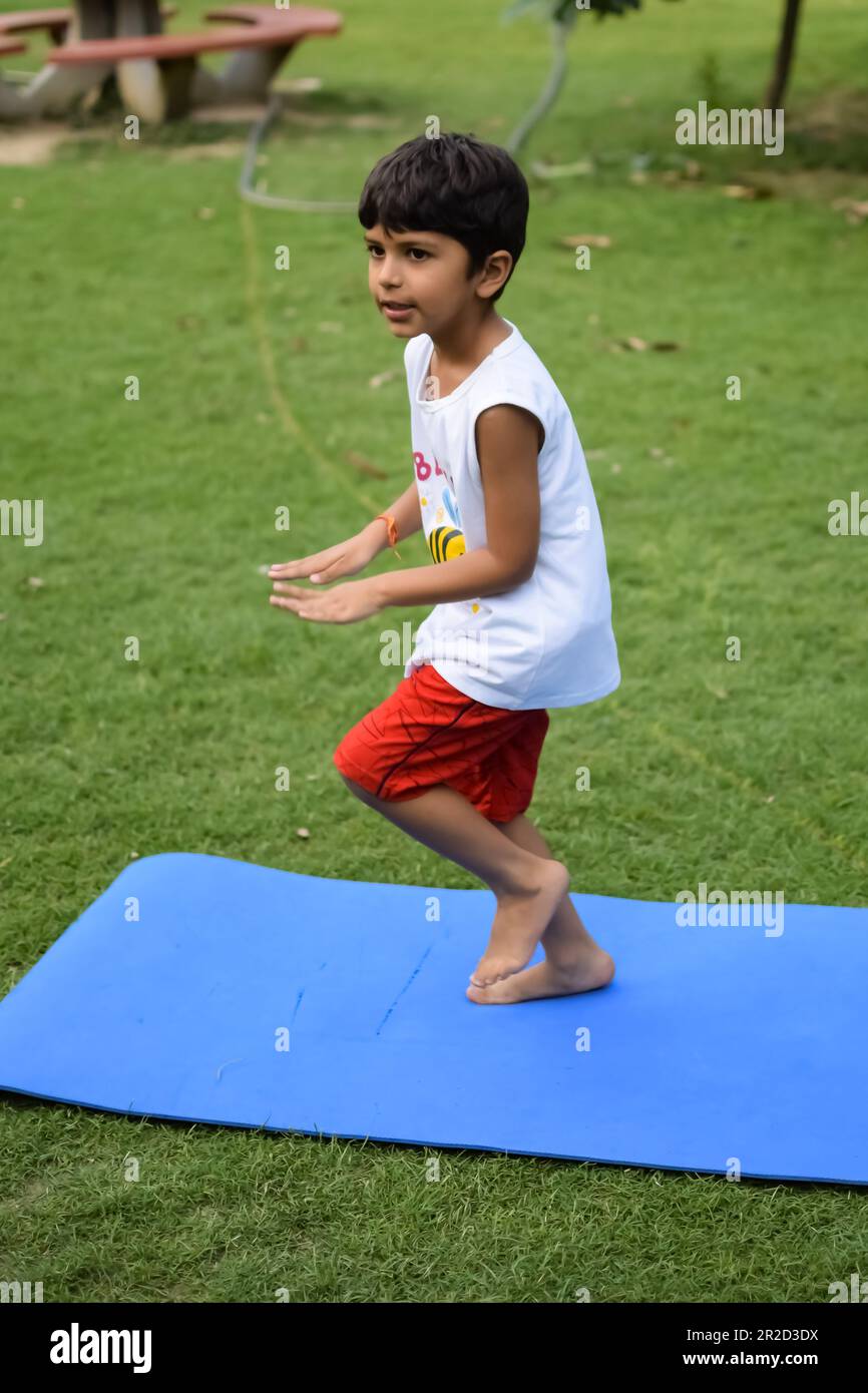 Asian smart kid doing yoga pose in the society park outdoor, Children's ...