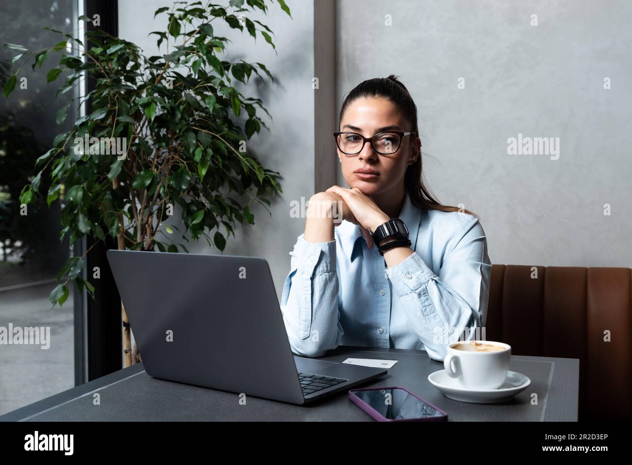 Young businesswoman feeling depressed while using computer in cafeteria ...