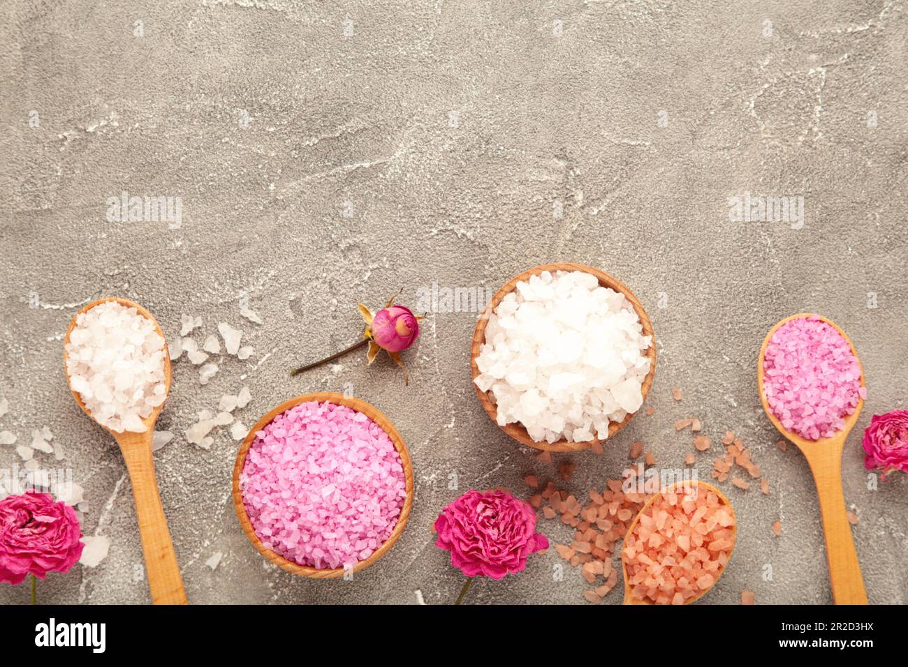 Different types of salt with roses on grey background.. Top view Stock ...