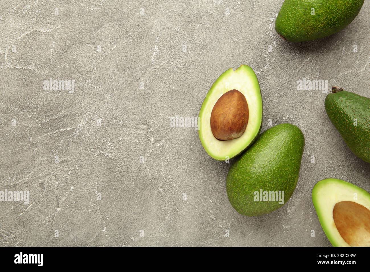 Fresh avocado and half of avocado on grey background. Top view Stock ...
