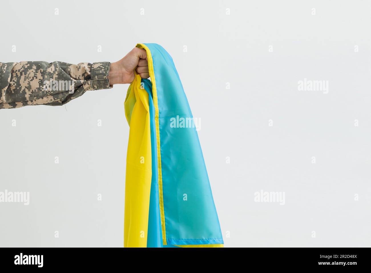 courageous Ukrainian military man holding the flag of Ukraine, freedom ...