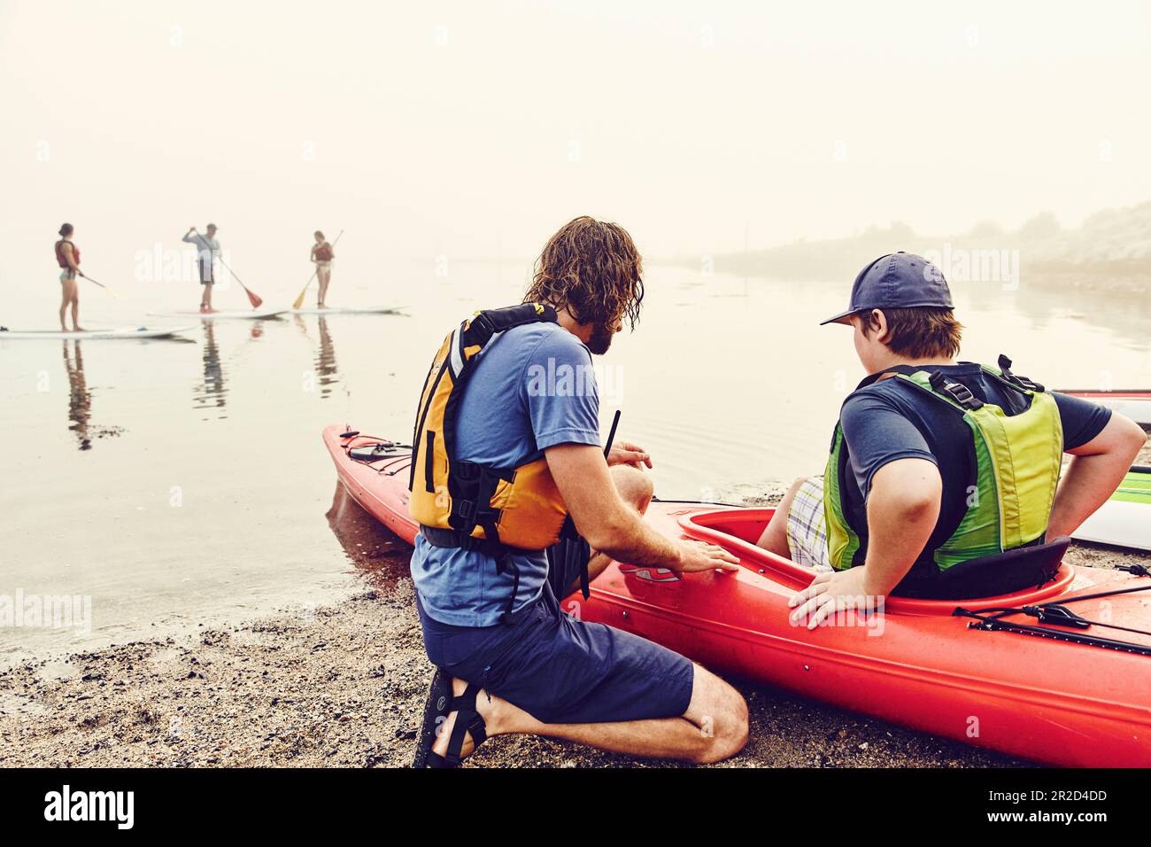Instructor helps his young student get ready for a kayaking trip Stock ...