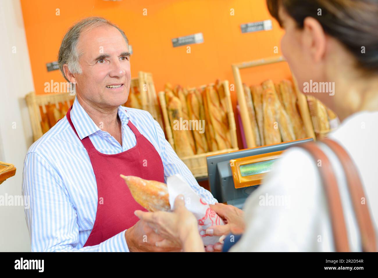Baker serving bread customer hi-res stock photography and images - Alamy