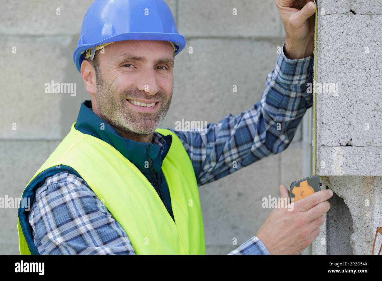 construction worker laying bricks and using measuring tape Stock Photo ...