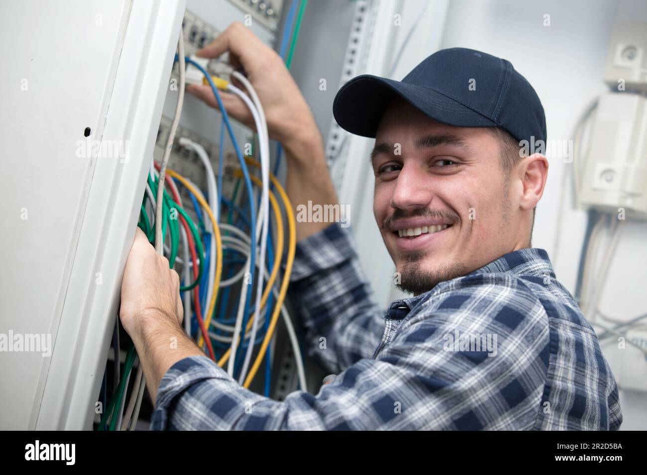 portrait of a smiling young computer technician with cables Stock Photo ...