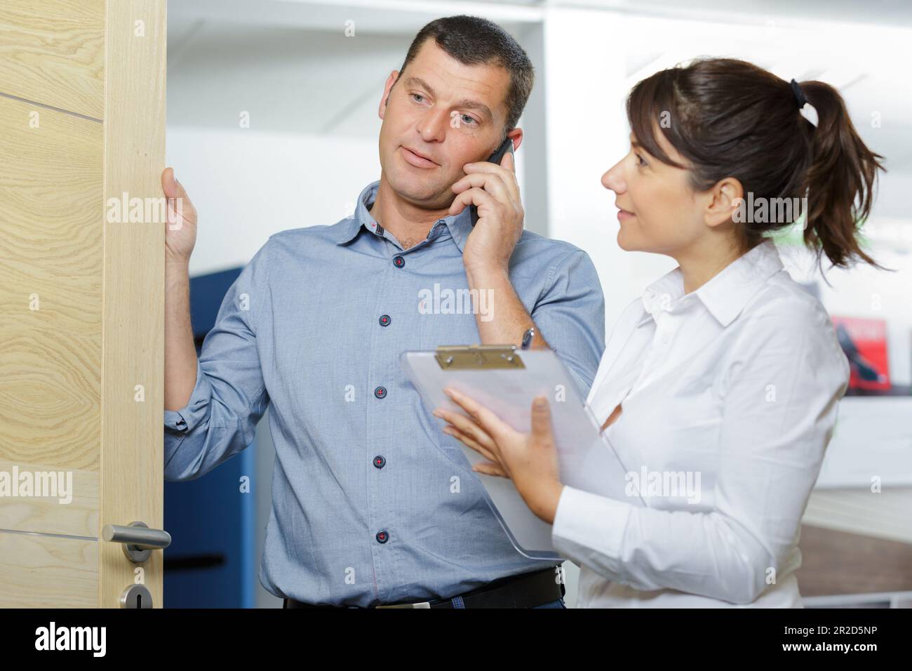 carpenter talking on phone in hardware store Stock Photo - Alamy