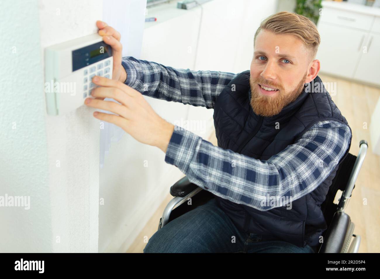 disabled male electrician installing security system door sensor on ...