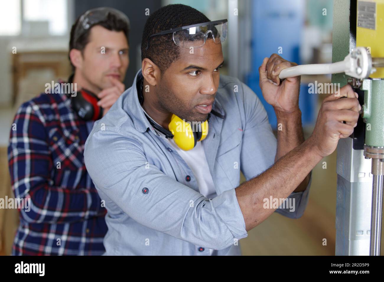 two men working on a machine Stock Photo - Alamy