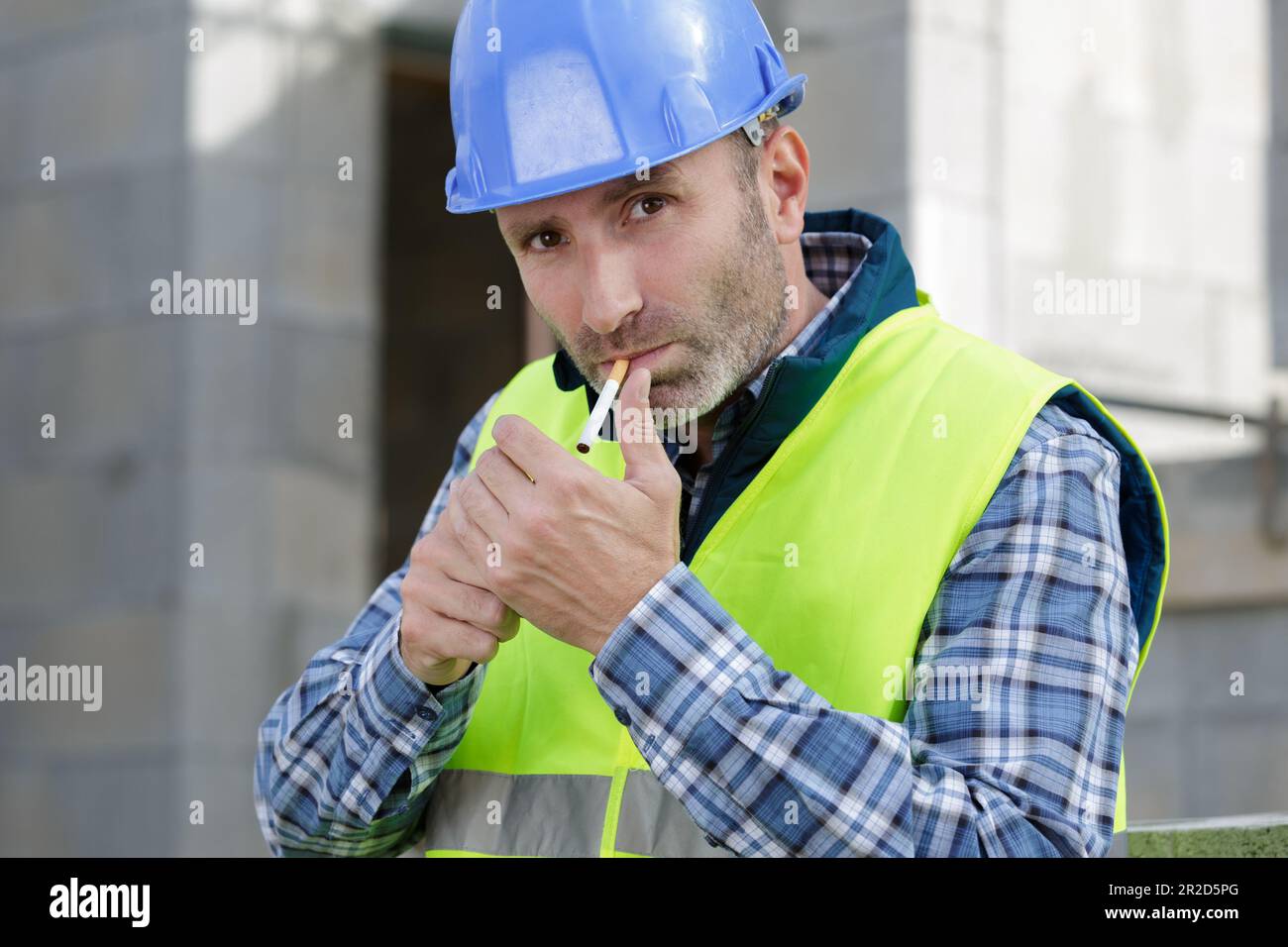 builder smoking cigarette on construction site Stock Photo - Alamy