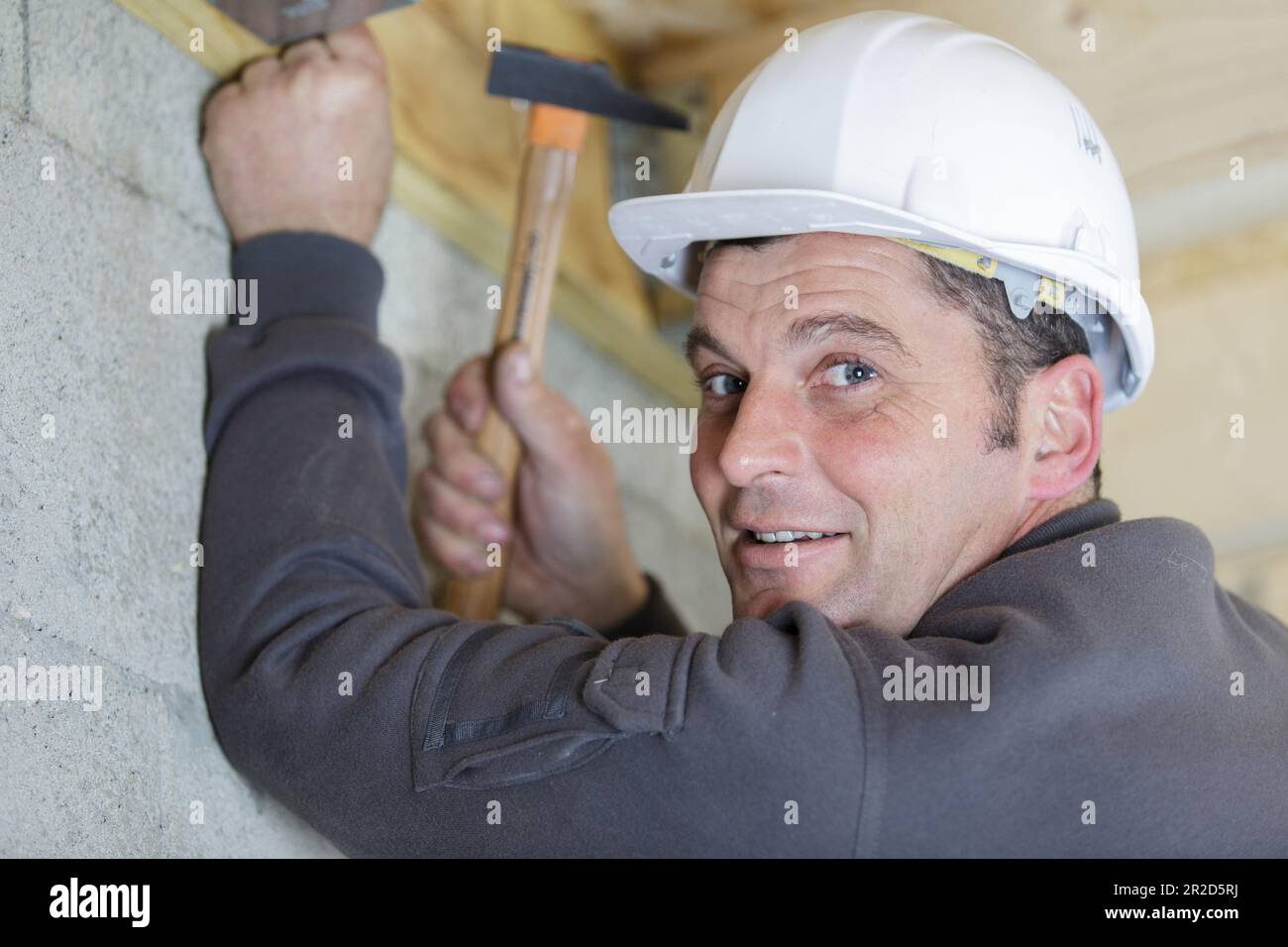 man hammers into the wall Stock Photo - Alamy