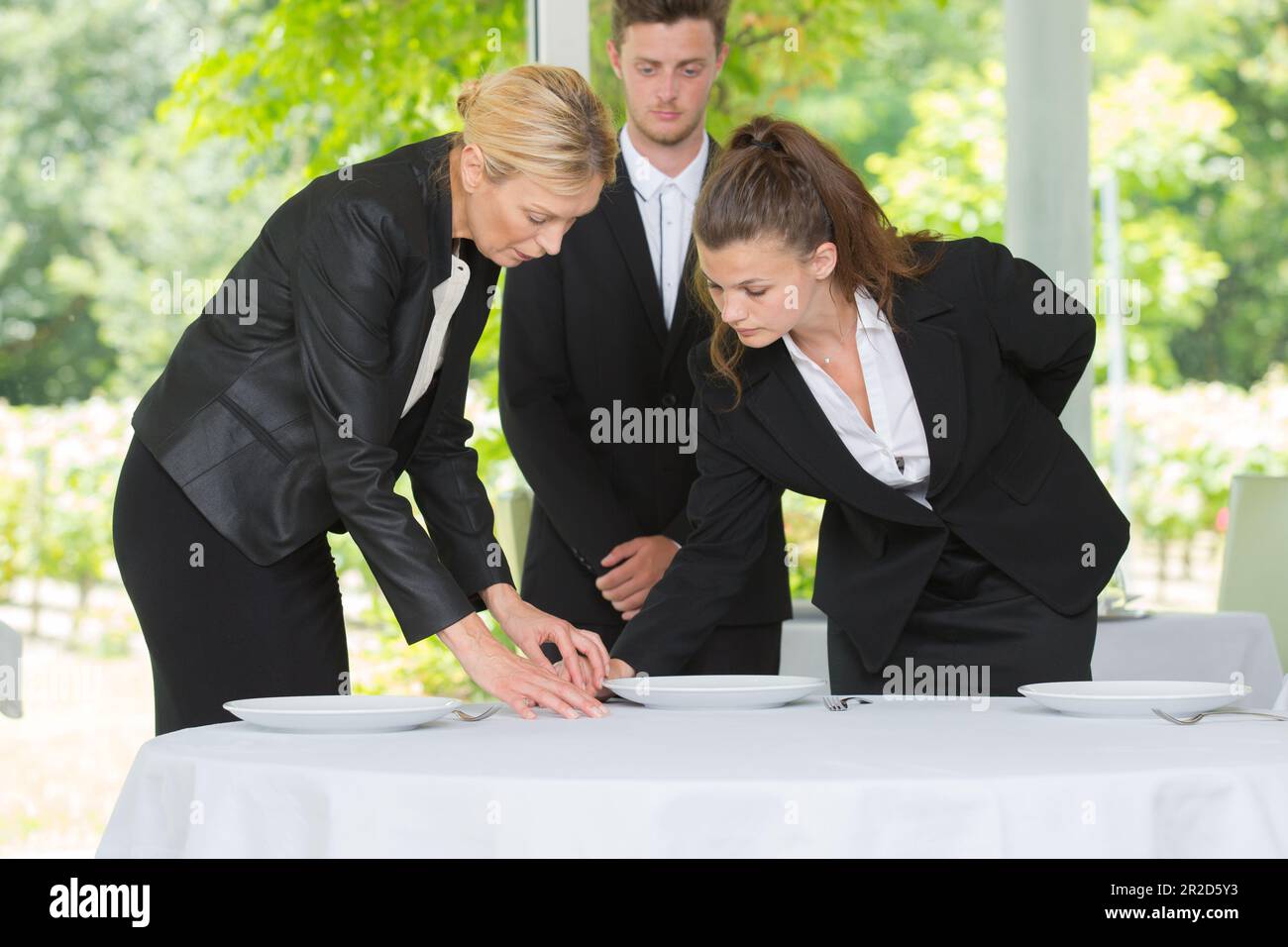 restaurant manager supervising work done by students Stock Photo - Alamy
