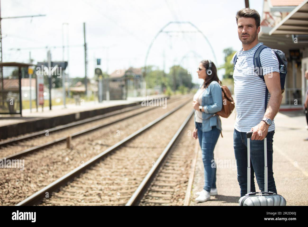 two people waiting at the train station Stock Photo - Alamy
