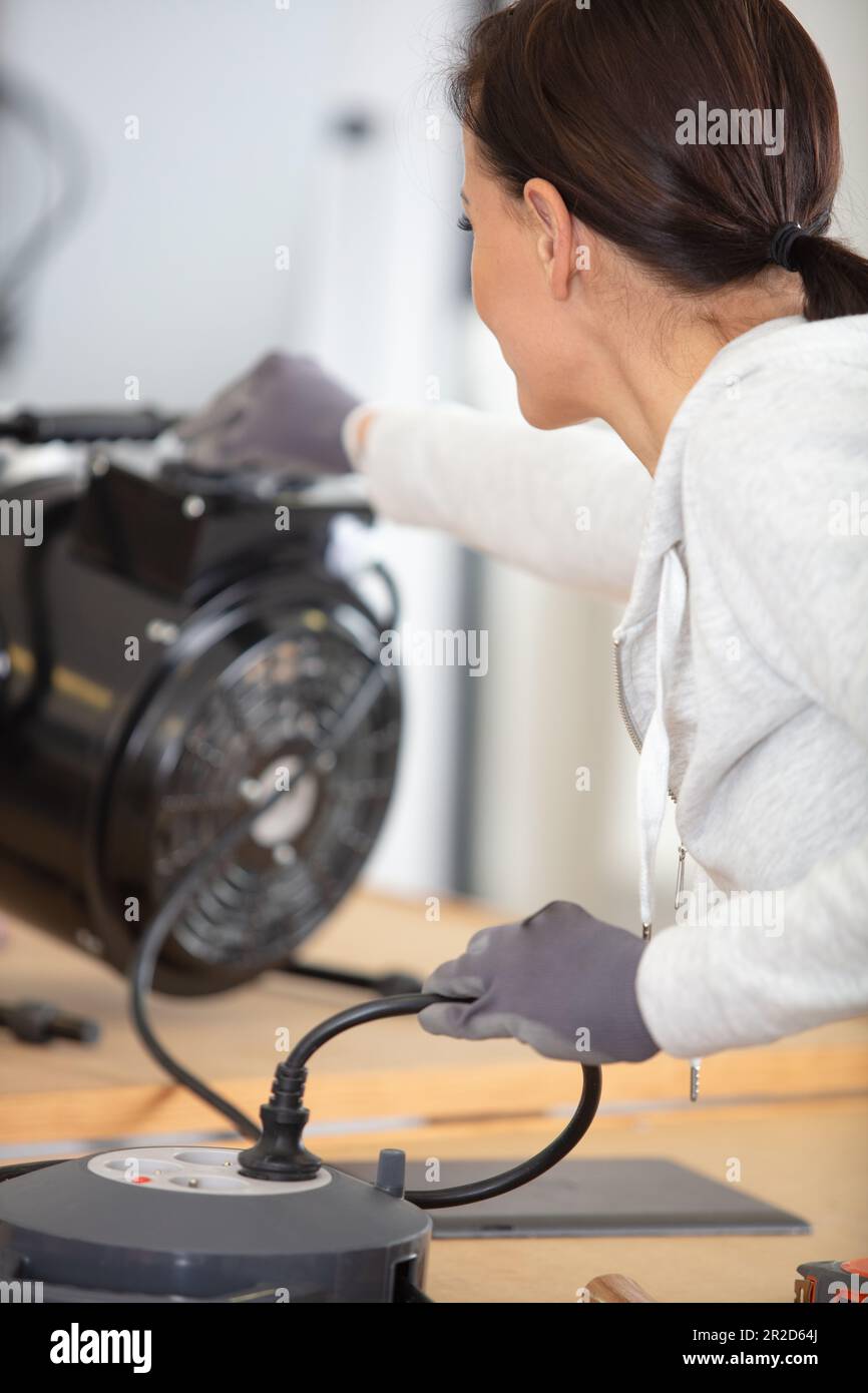a woman looks at the electrical device Stock Photo - Alamy