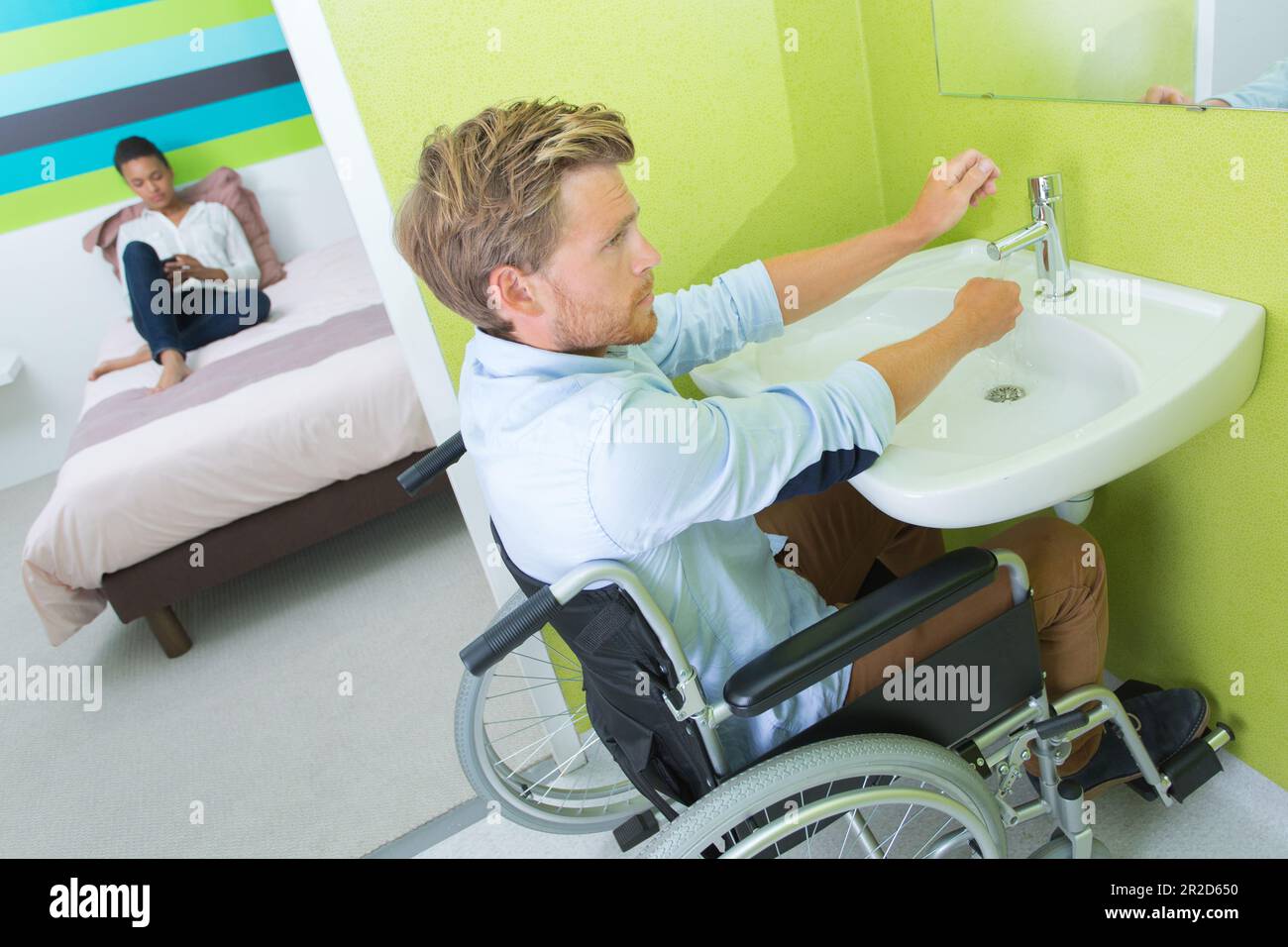 man on wheelchair washing hands in bathroom Stock Photo - Alamy